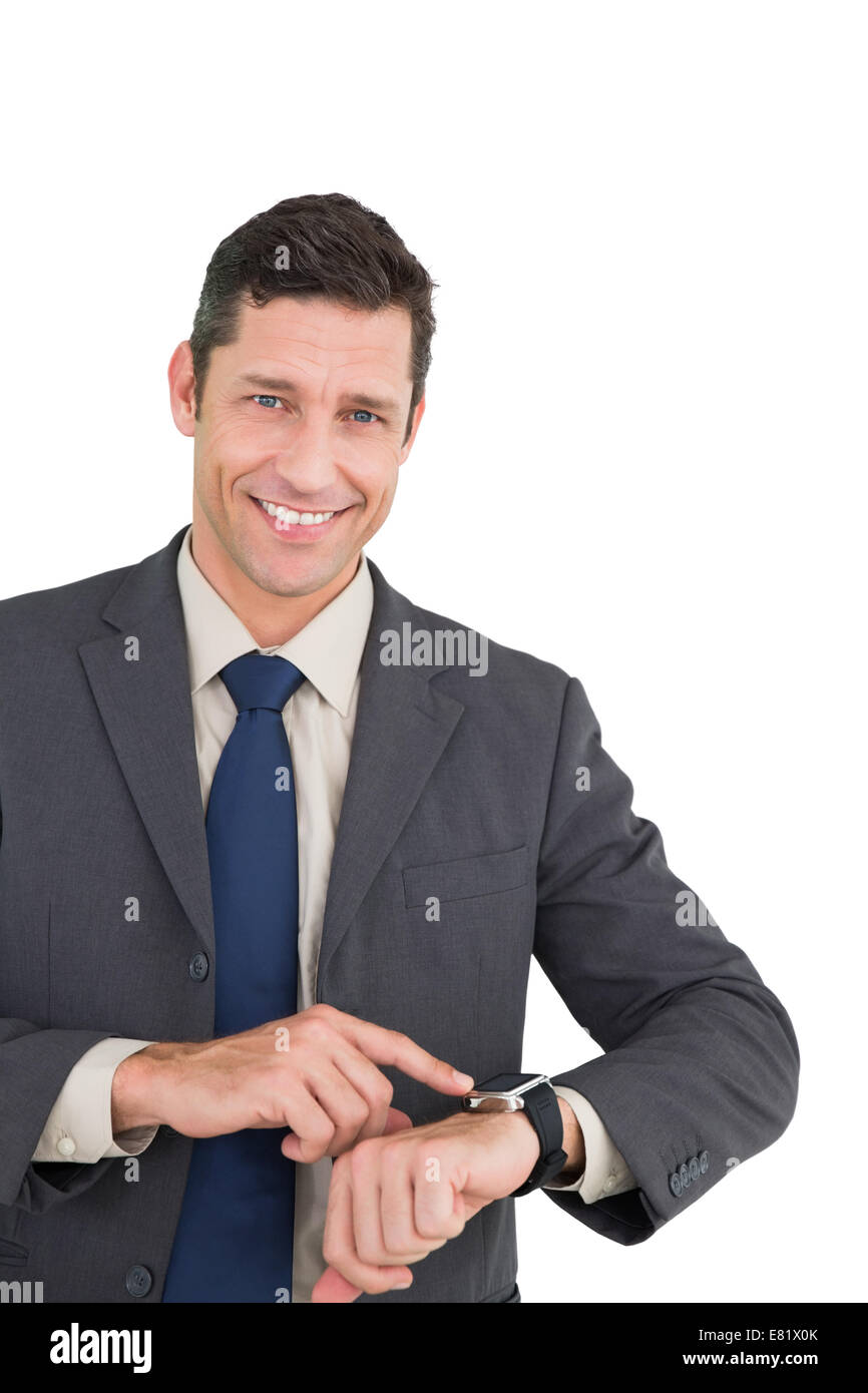 Businessman using his smart watch and smiling at camera Stock Photo - Alamy