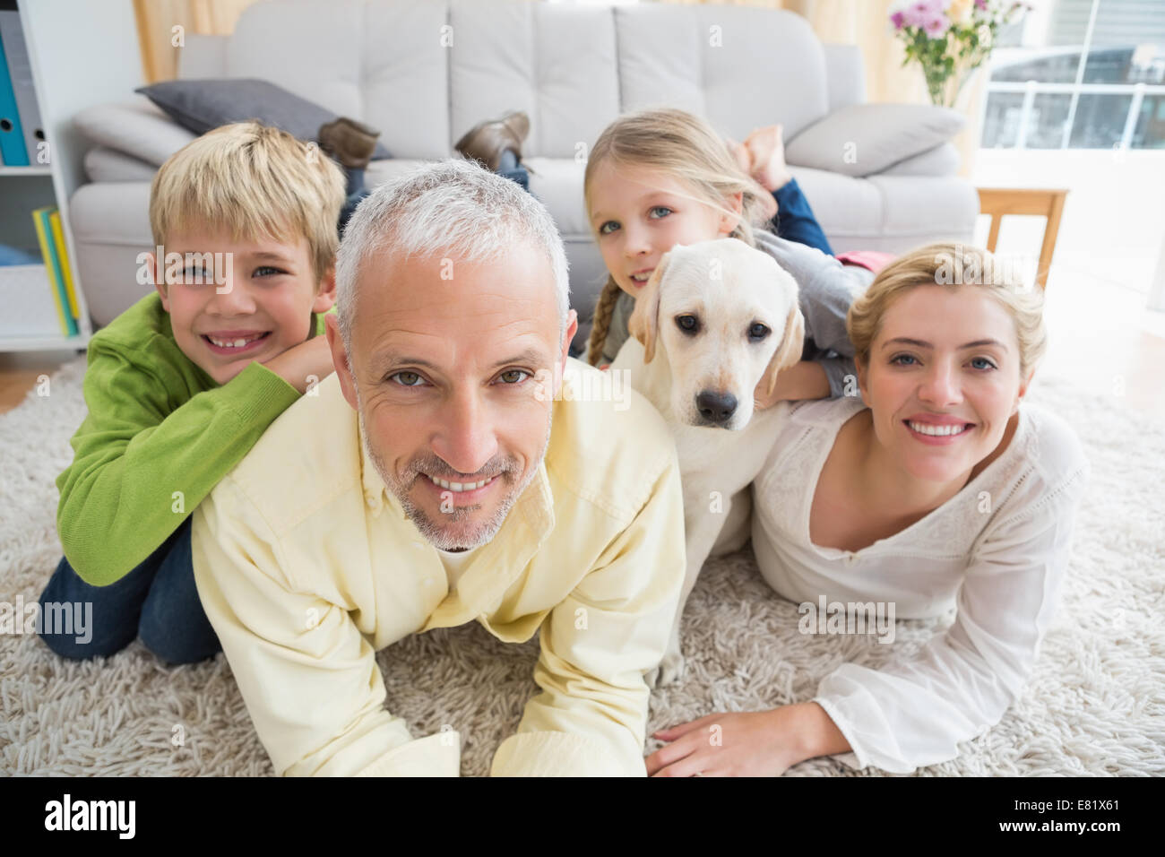 Happy parents with their children and puppy on floor Stock Photo - Alamy