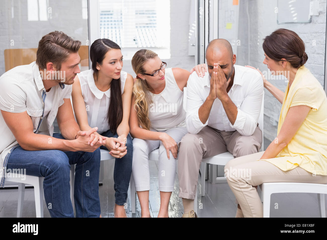 Business team sitting together supporting sad colleague Stock Photo - Alamy