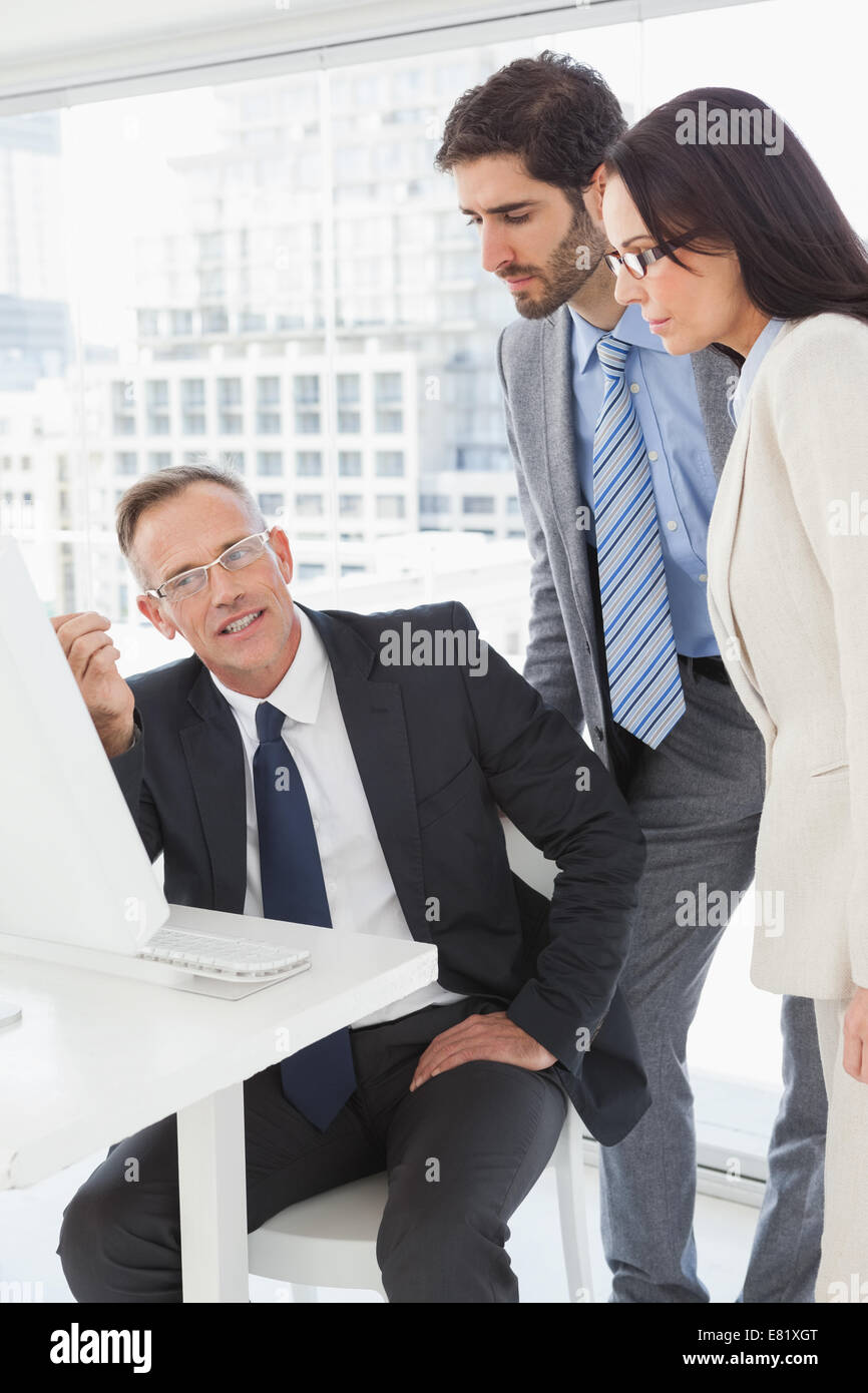 Business people looking at a computer Stock Photo - Alamy