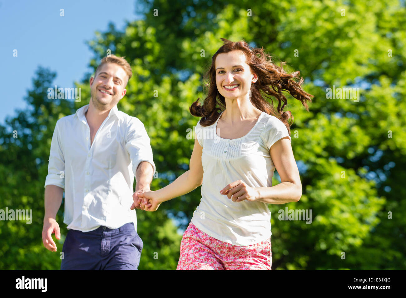 Couple in love running through park Stock Photo - Alamy
