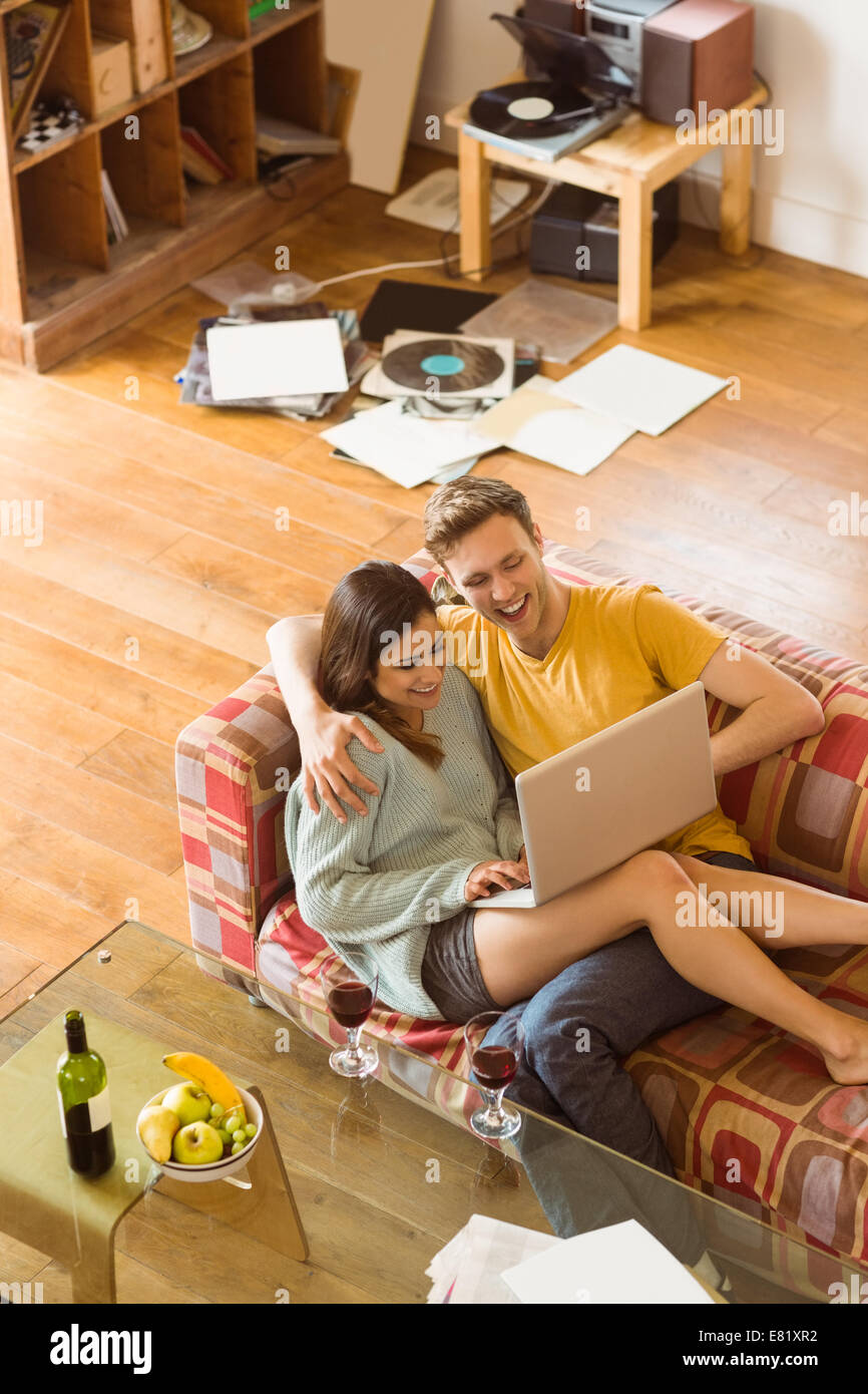 Young couple cuddling on the couch with laptop Stock Photo - Alamy