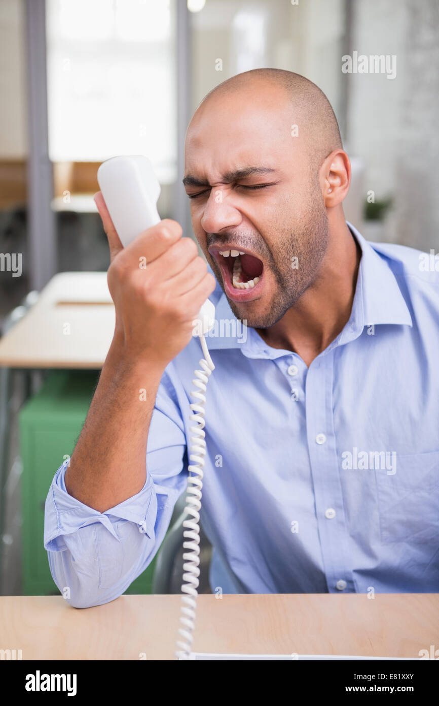 Angry businessman using telephone Stock Photo - Alamy