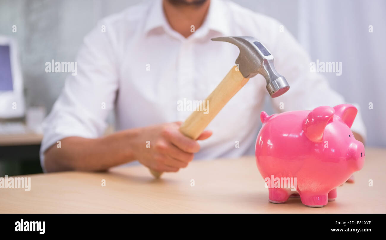 Man breaking piggy bank with hammer Stock Photo - Alamy