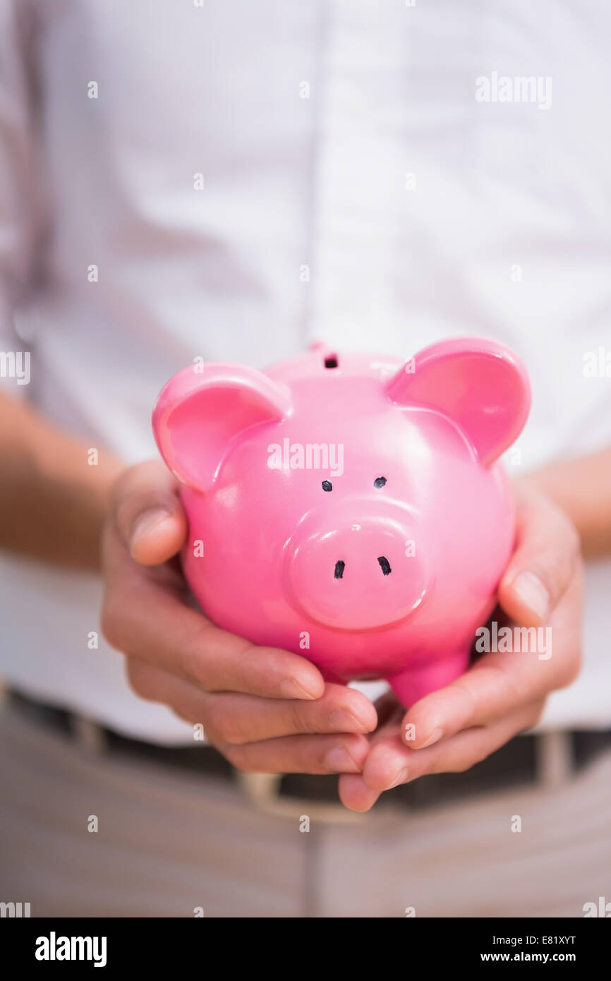 Mid section of man holding piggy bank Stock Photo - Alamy
