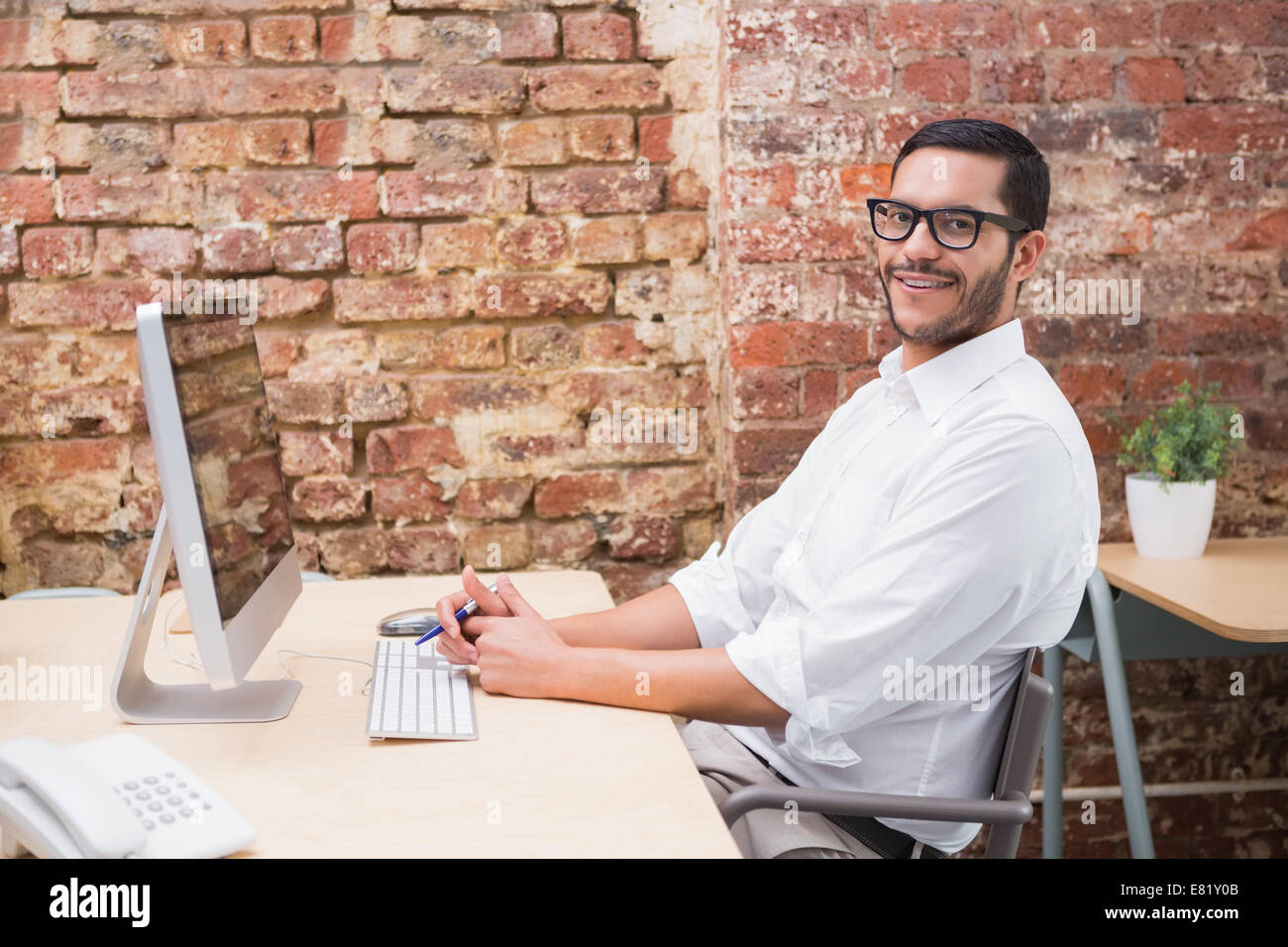 Portrait of businessman with computer at desk Stock Photo - Alamy