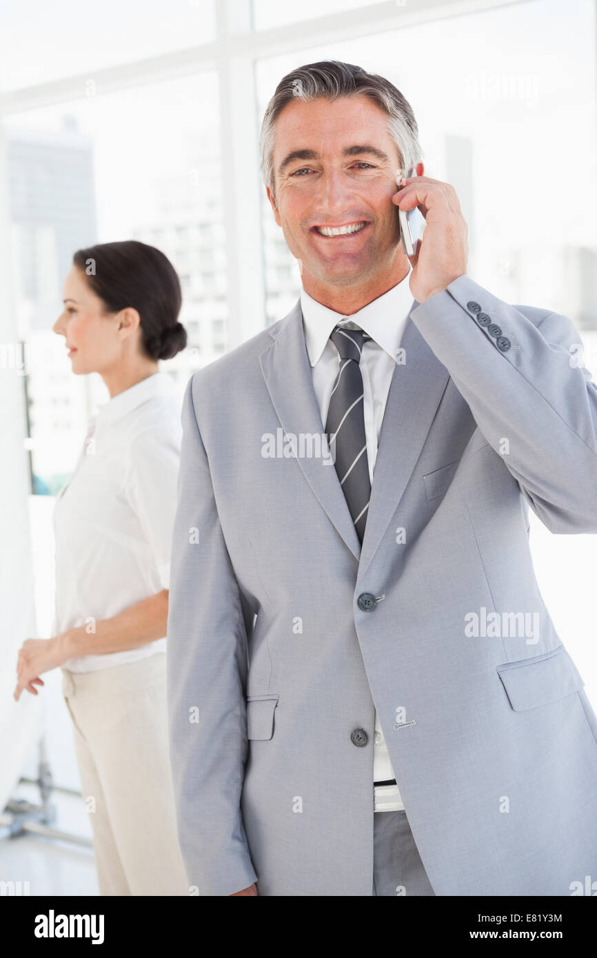 Smiling businessman using his phone Stock Photo - Alamy