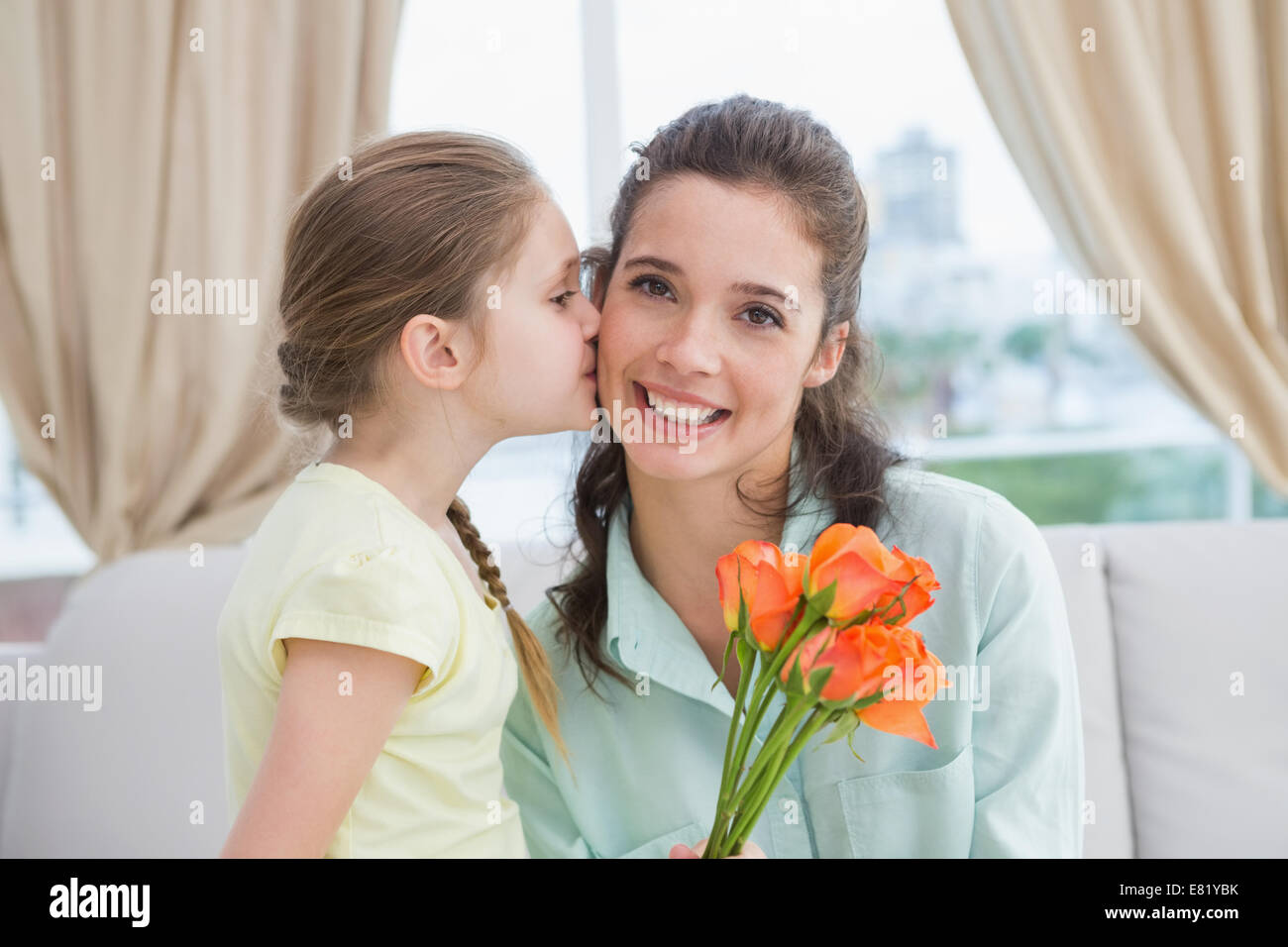 Cute girl giving flowers to mother Stock Photo - Alamy