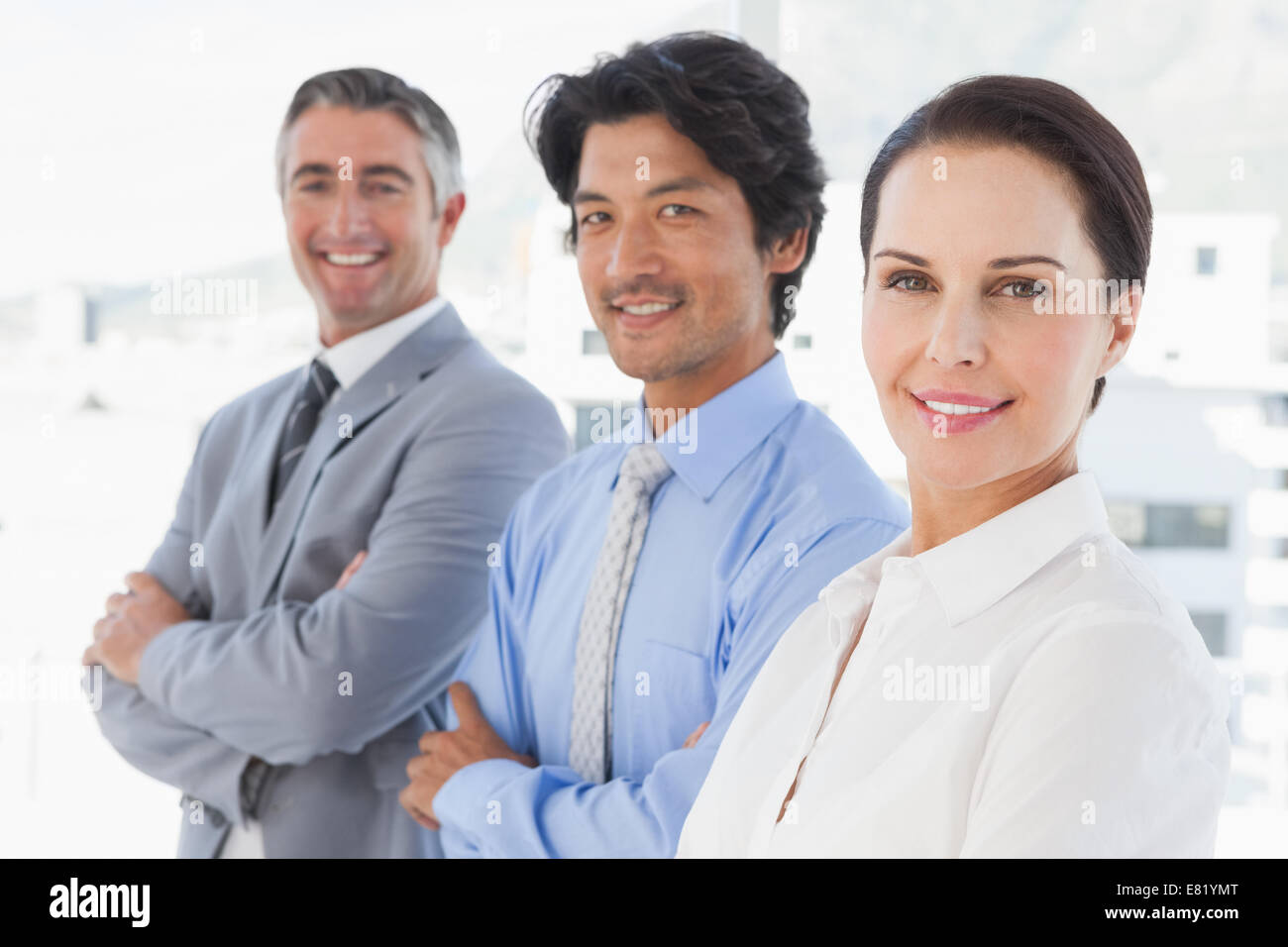 Smiling work colleagues standing together Stock Photo - Alamy