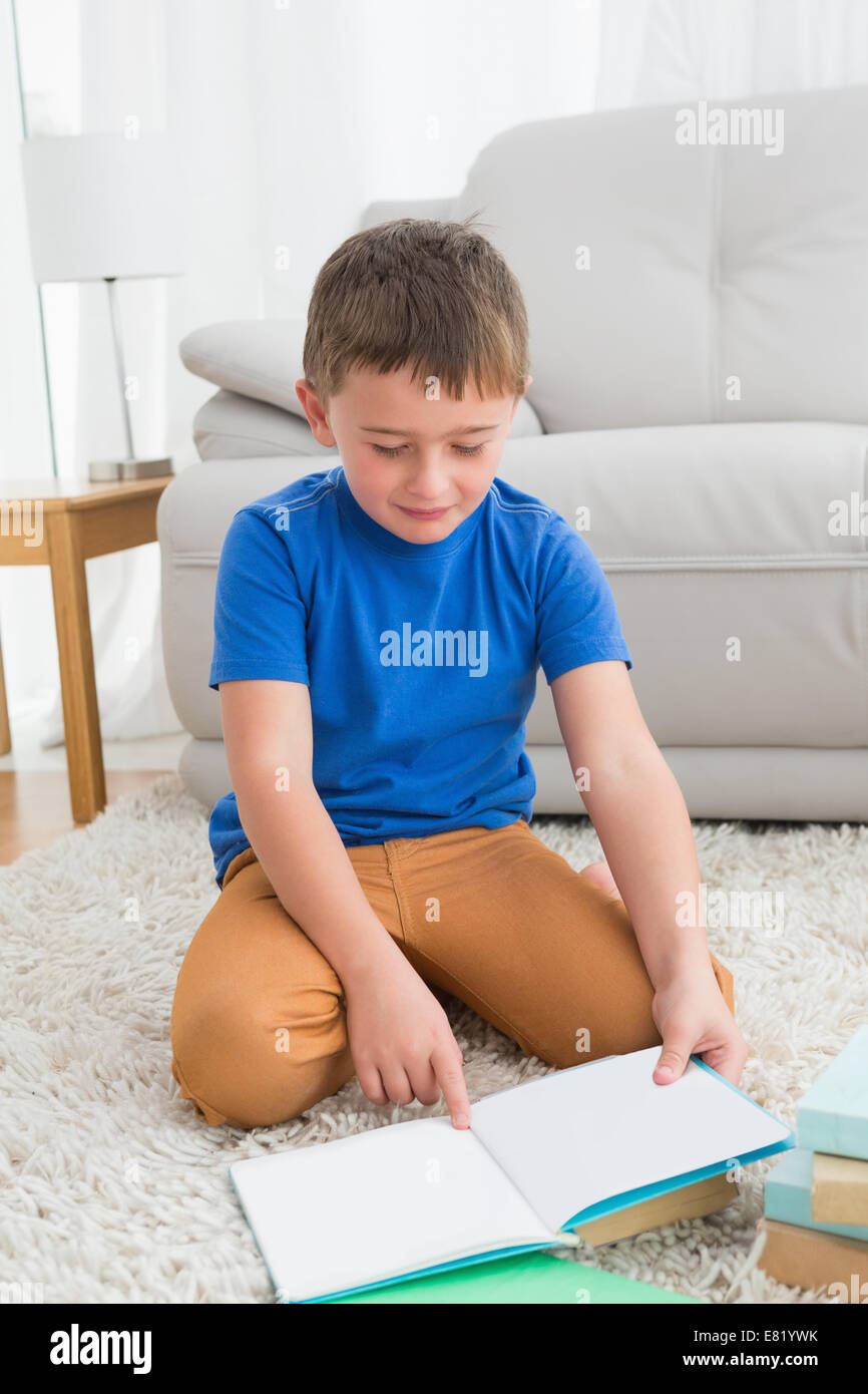 Boy sitting on floor reading book hi-res stock photography and images ...