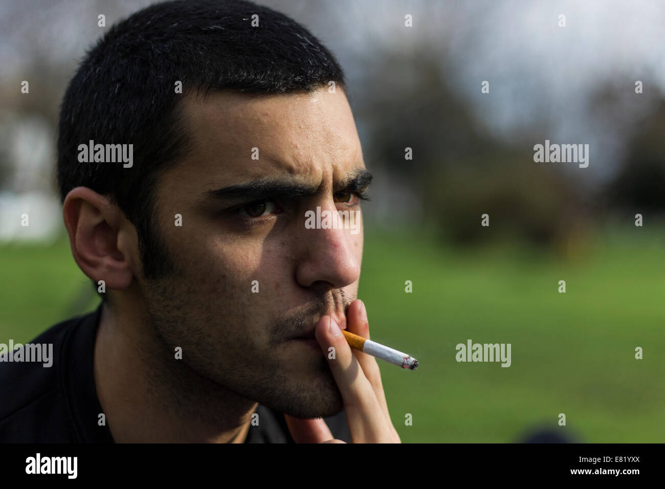 Young man smoking a cigarette Stock Photo - Alamy