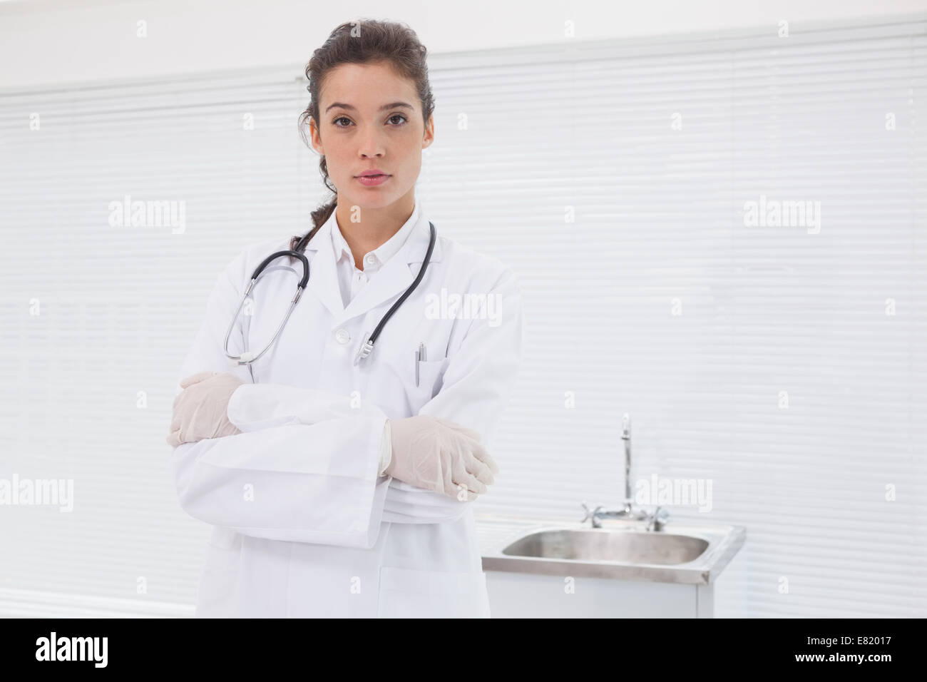 Concentrated doctor standing with stethoscope Stock Photo - Alamy