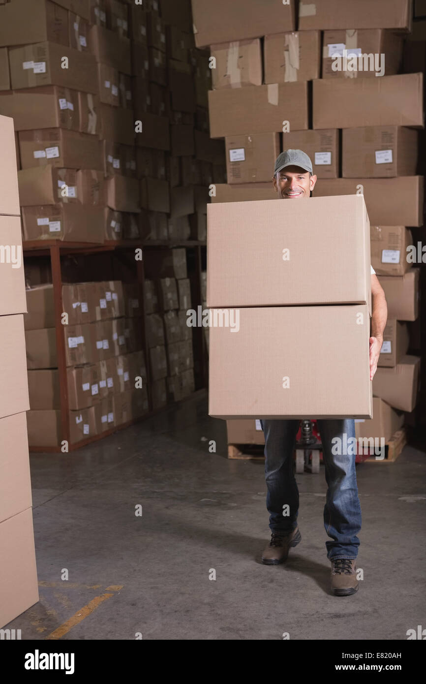 Worker with boxes in warehouse Stock Photo - Alamy