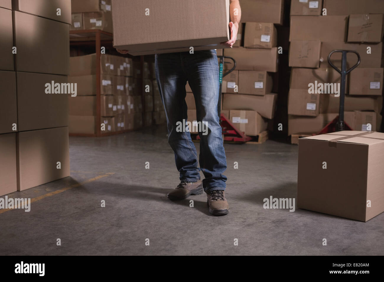 Worker with box in warehouse Stock Photo - Alamy