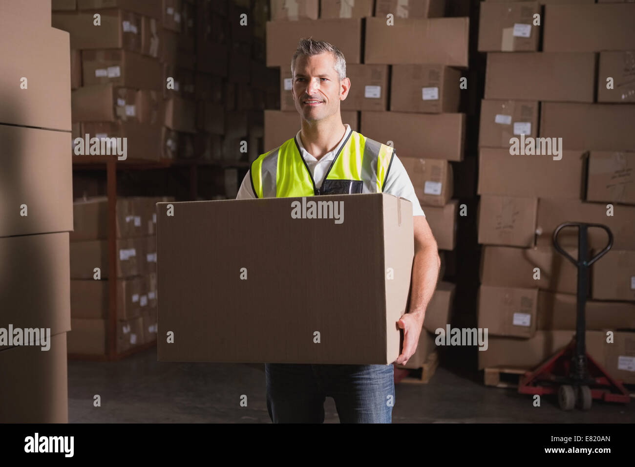 Worker with box in warehouse Stock Photo - Alamy