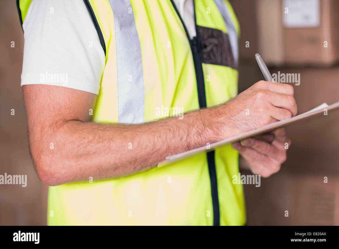 Mid section of warehouse worker with clipboard Stock Photo - Alamy