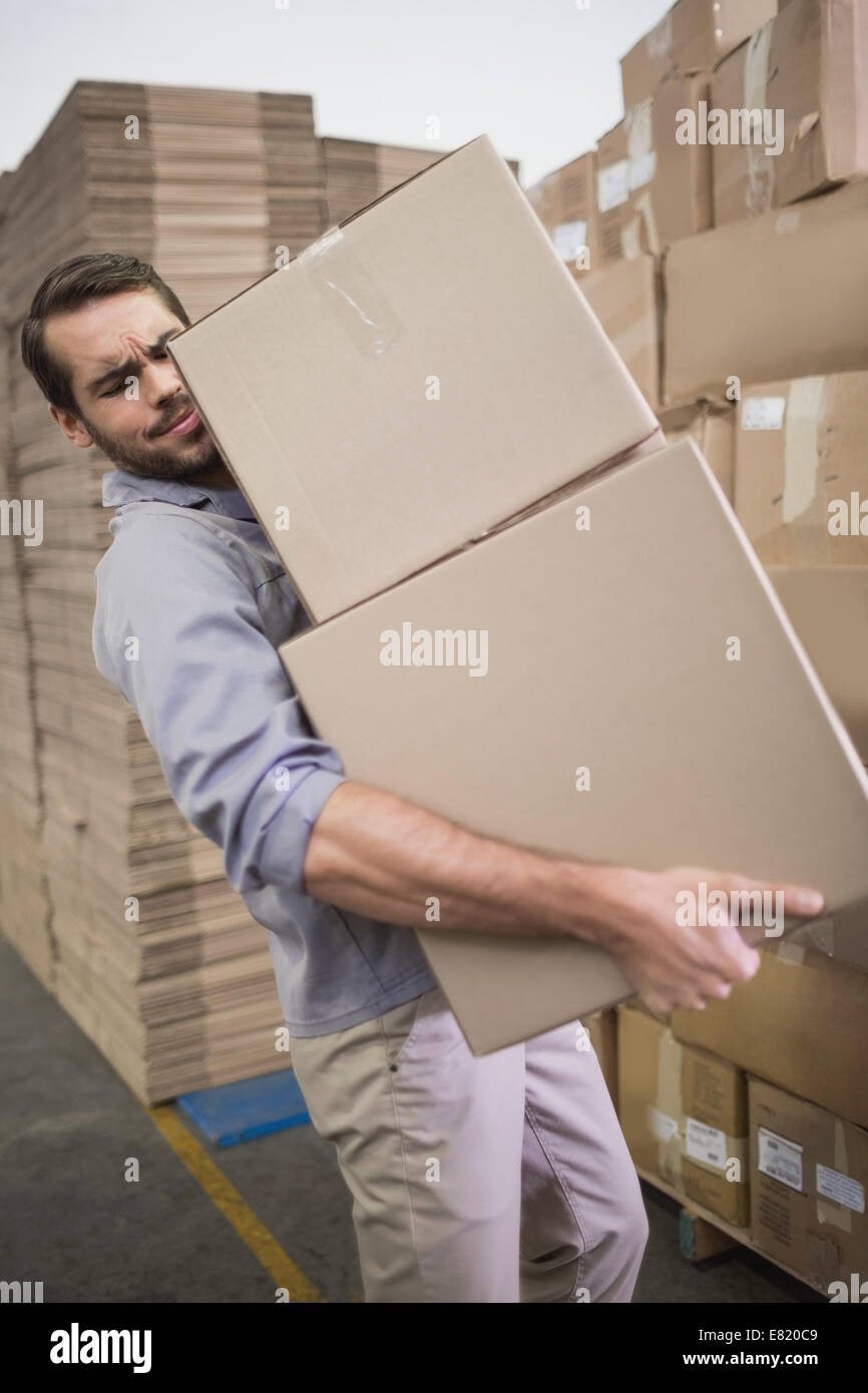 Worker carrying boxes in warehouse Stock Photo - Alamy