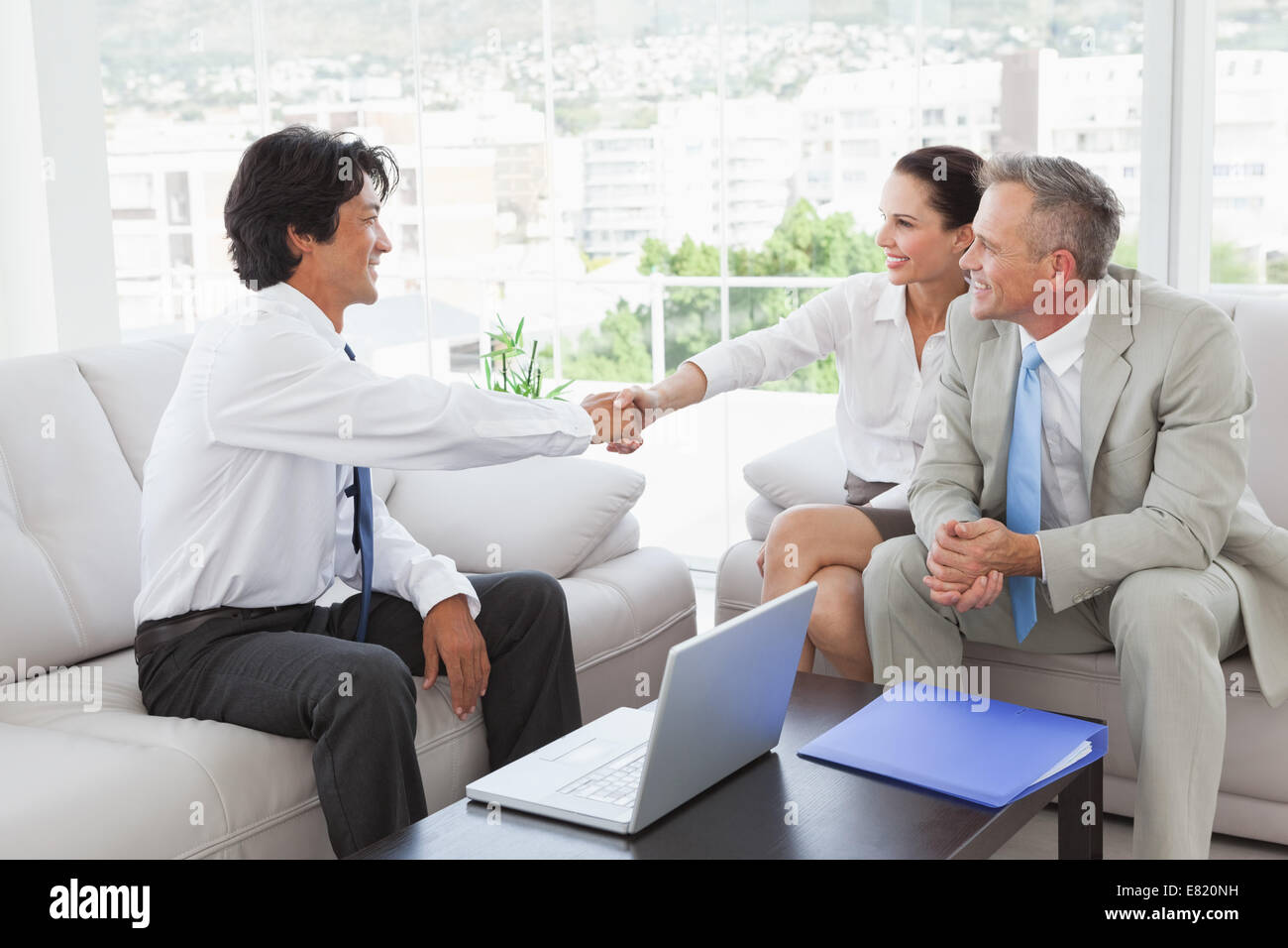 Businessman shaking a clients hand Stock Photo - Alamy