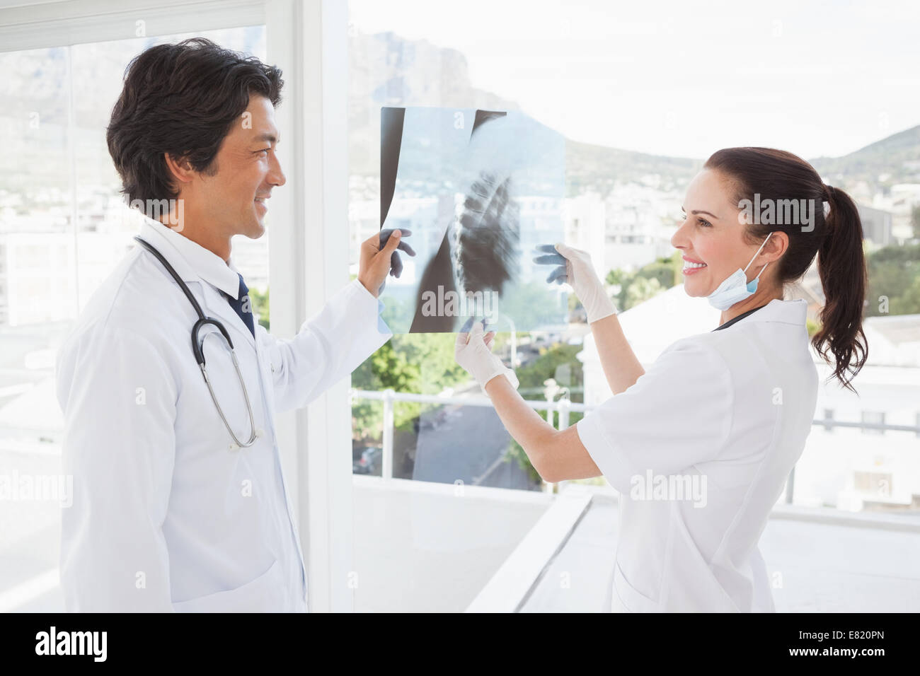Smiling doctors holding an x ray Stock Photo - Alamy