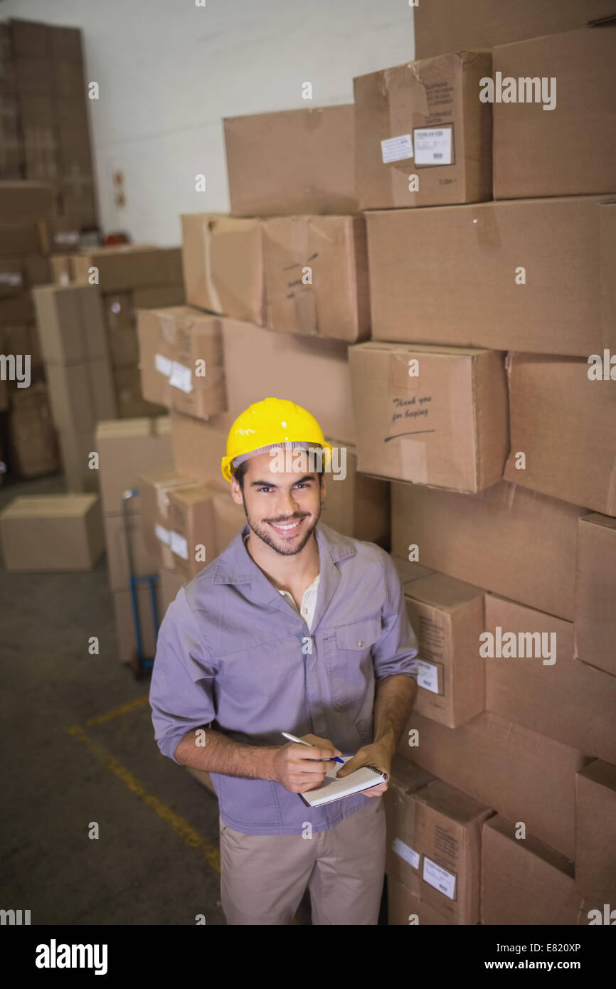 Worker with clipboard in warehouse Stock Photo - Alamy