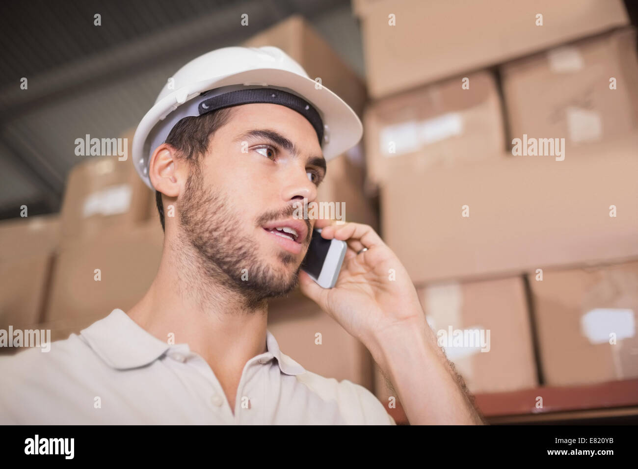 Worker using cellphone in warehouse Stock Photo - Alamy