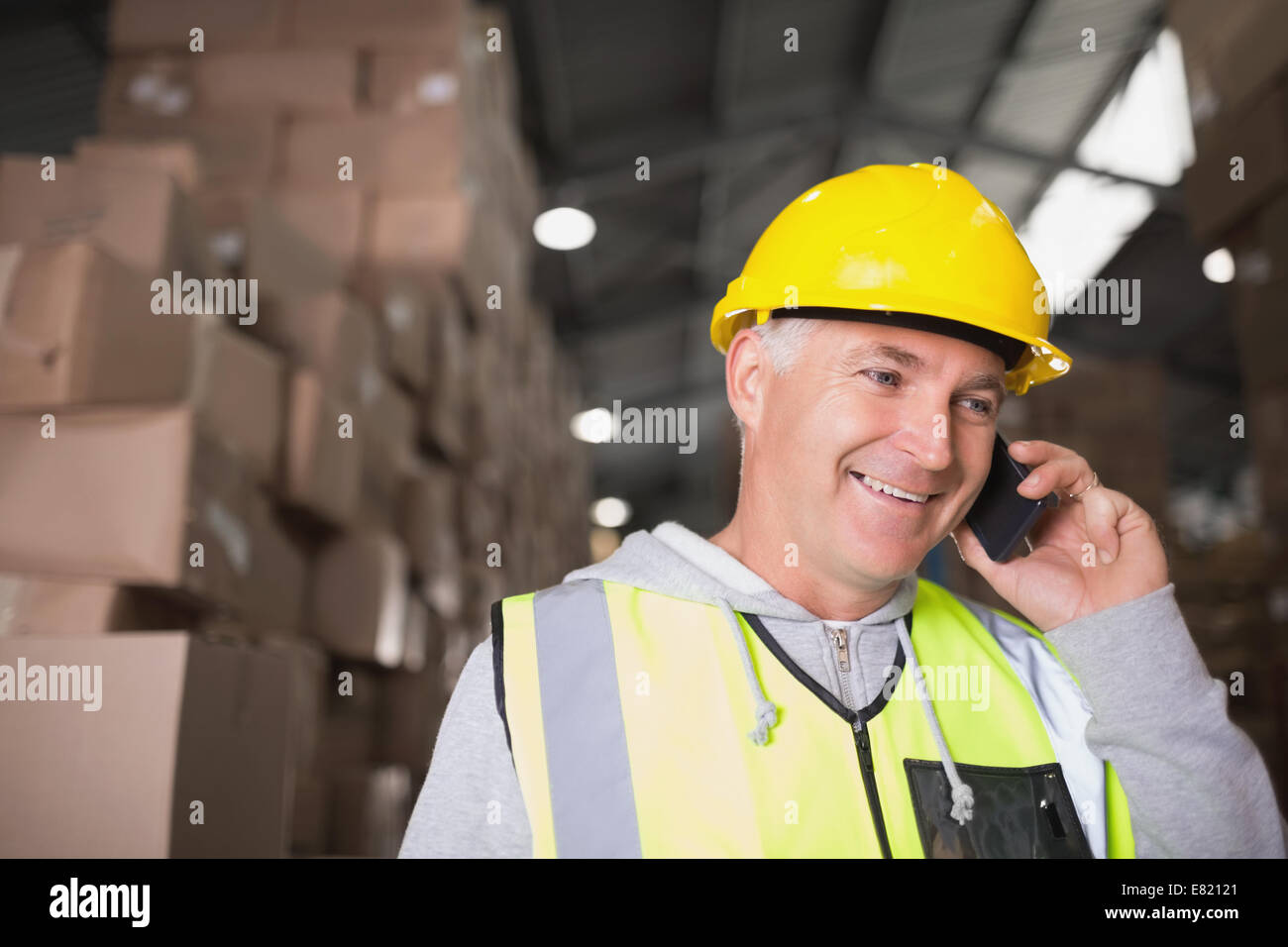 Worker using mobile phone in warehouse Stock Photo - Alamy