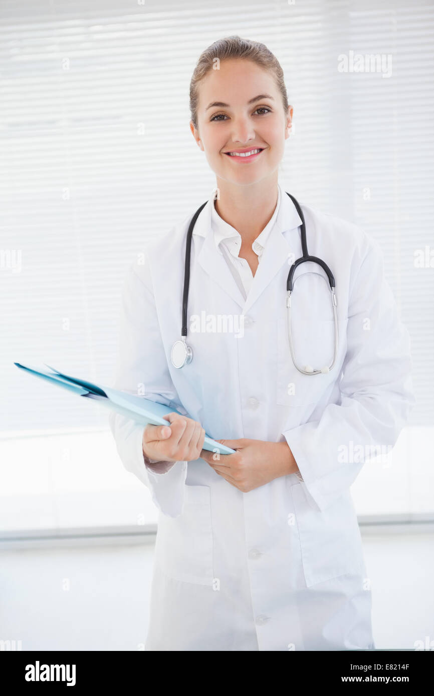 Smiling doctor holding some files Stock Photo - Alamy