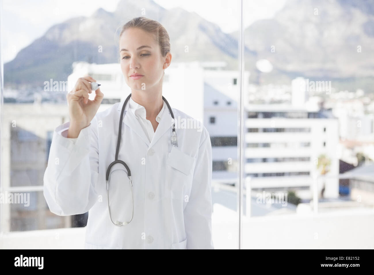 Doctor writing on a clear board Stock Photo - Alamy