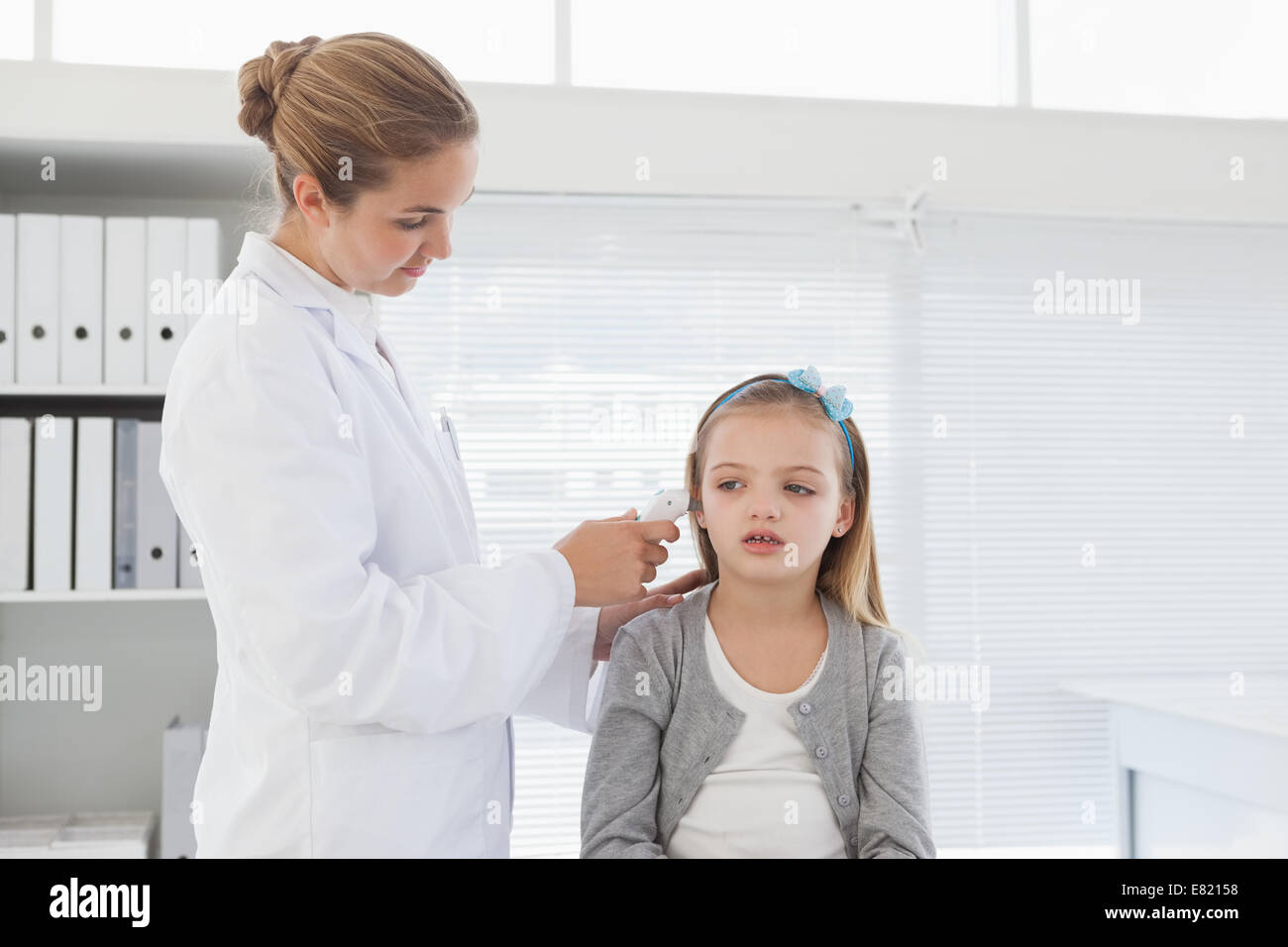 Doctor checking patients ear Stock Photo - Alamy