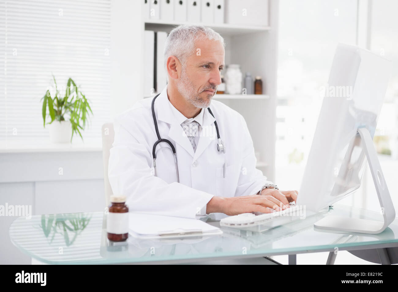 Happy doctor typing on keyboard Stock Photo - Alamy