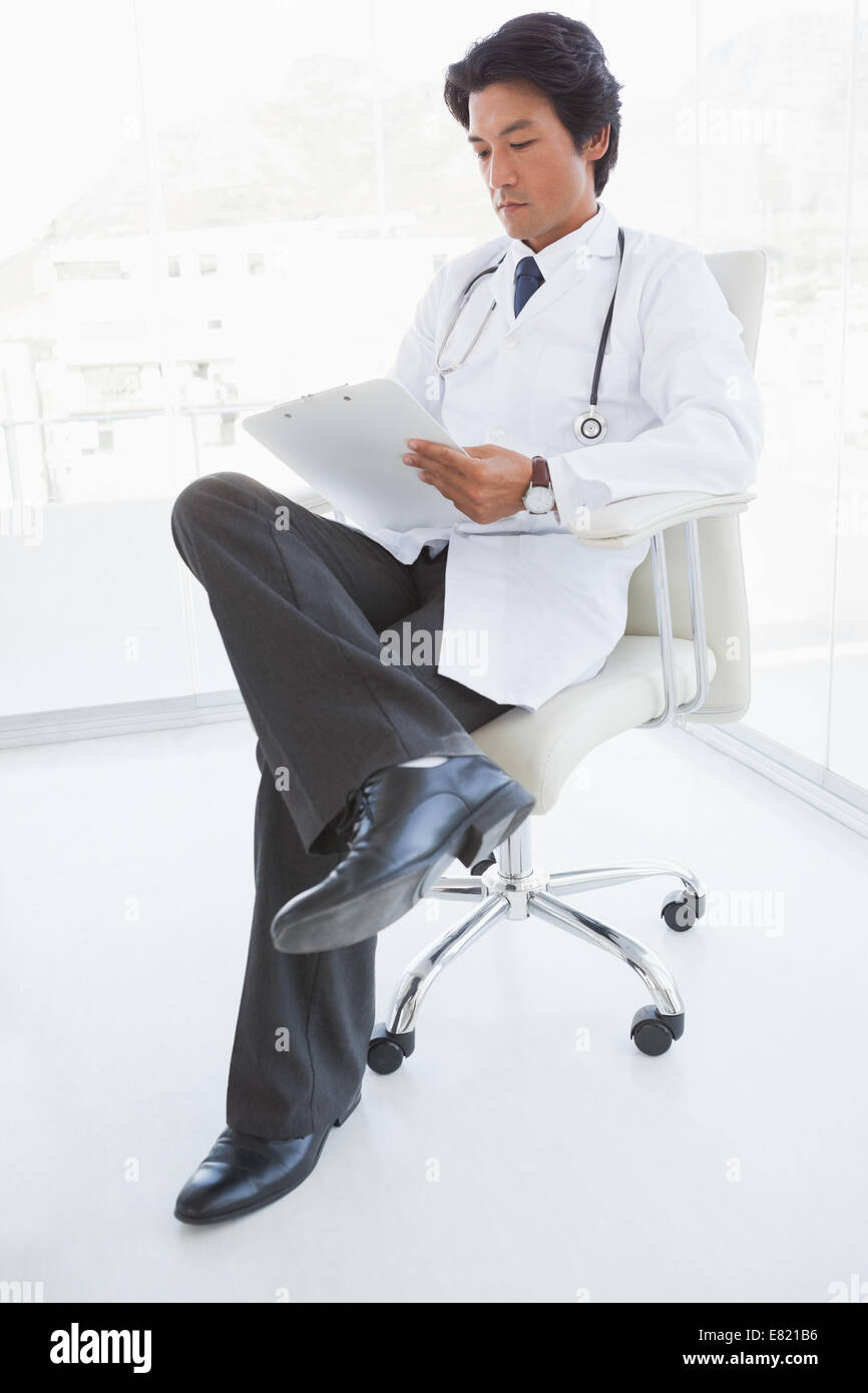 Focused doctor reading over notes Stock Photo - Alamy