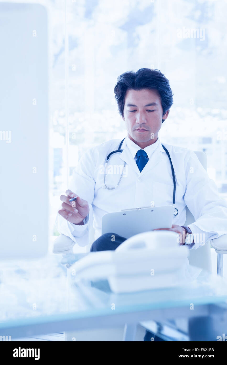 Focused doctor reading over notes Stock Photo - Alamy