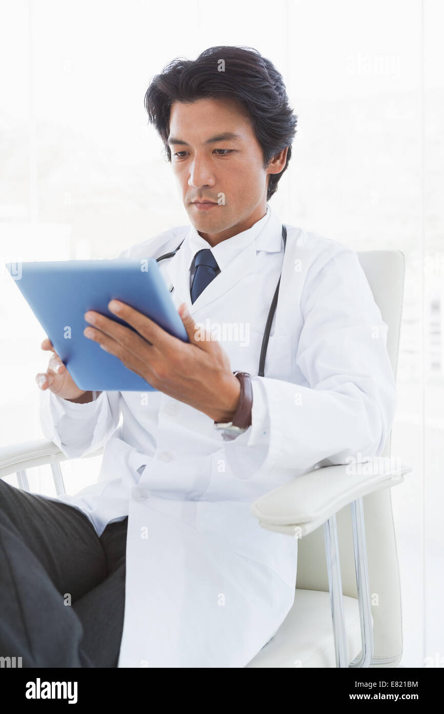 Concentrating doctor using a tablet Stock Photo - Alamy