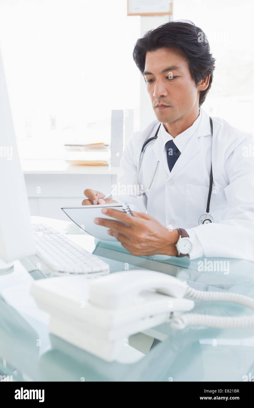 Focused doctor writing down notes Stock Photo - Alamy