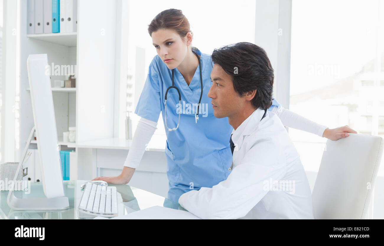 Doctor and surgeon looking at a computer Stock Photo - Alamy