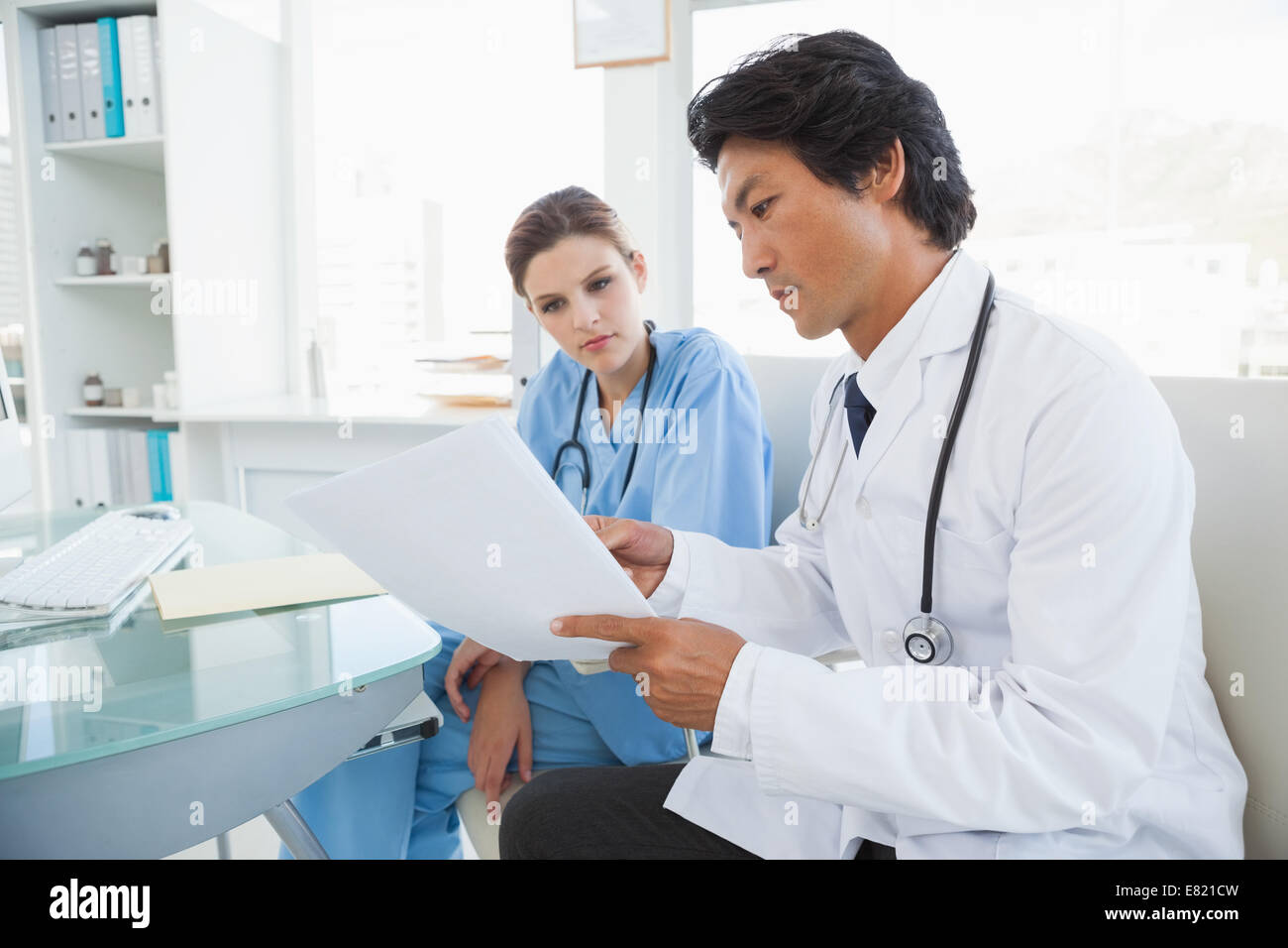 Doctor and surgeon reading notes Stock Photo - Alamy