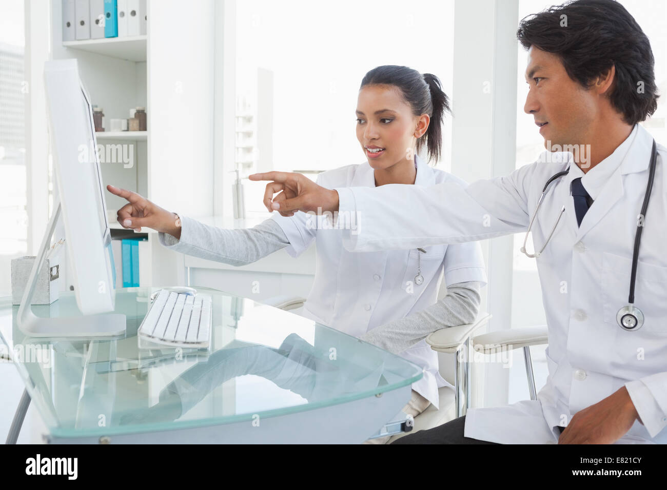 Two doctors pointing to computer screen Stock Photo - Alamy