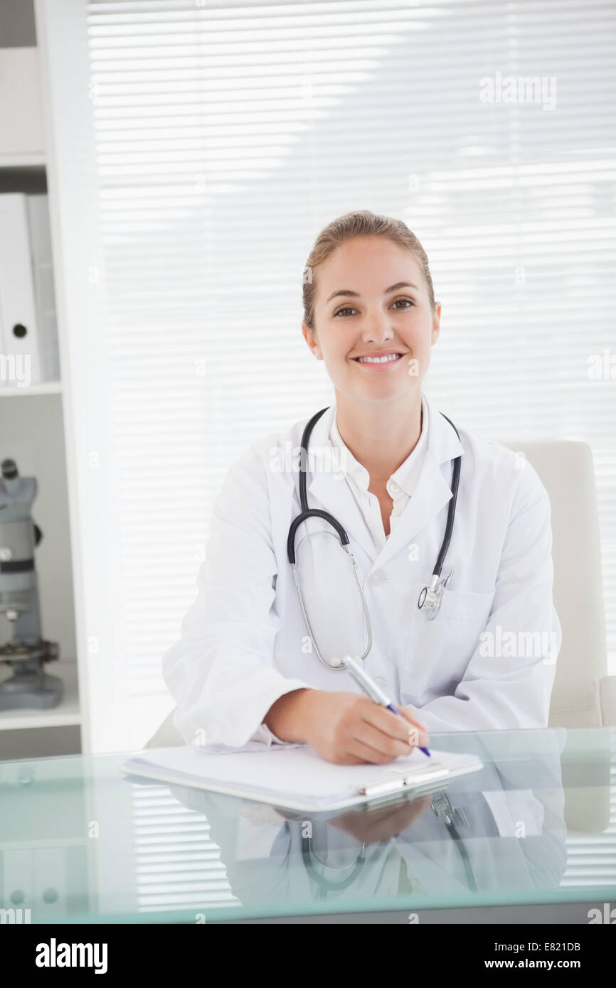 Smiling doctor taking some notes Stock Photo - Alamy