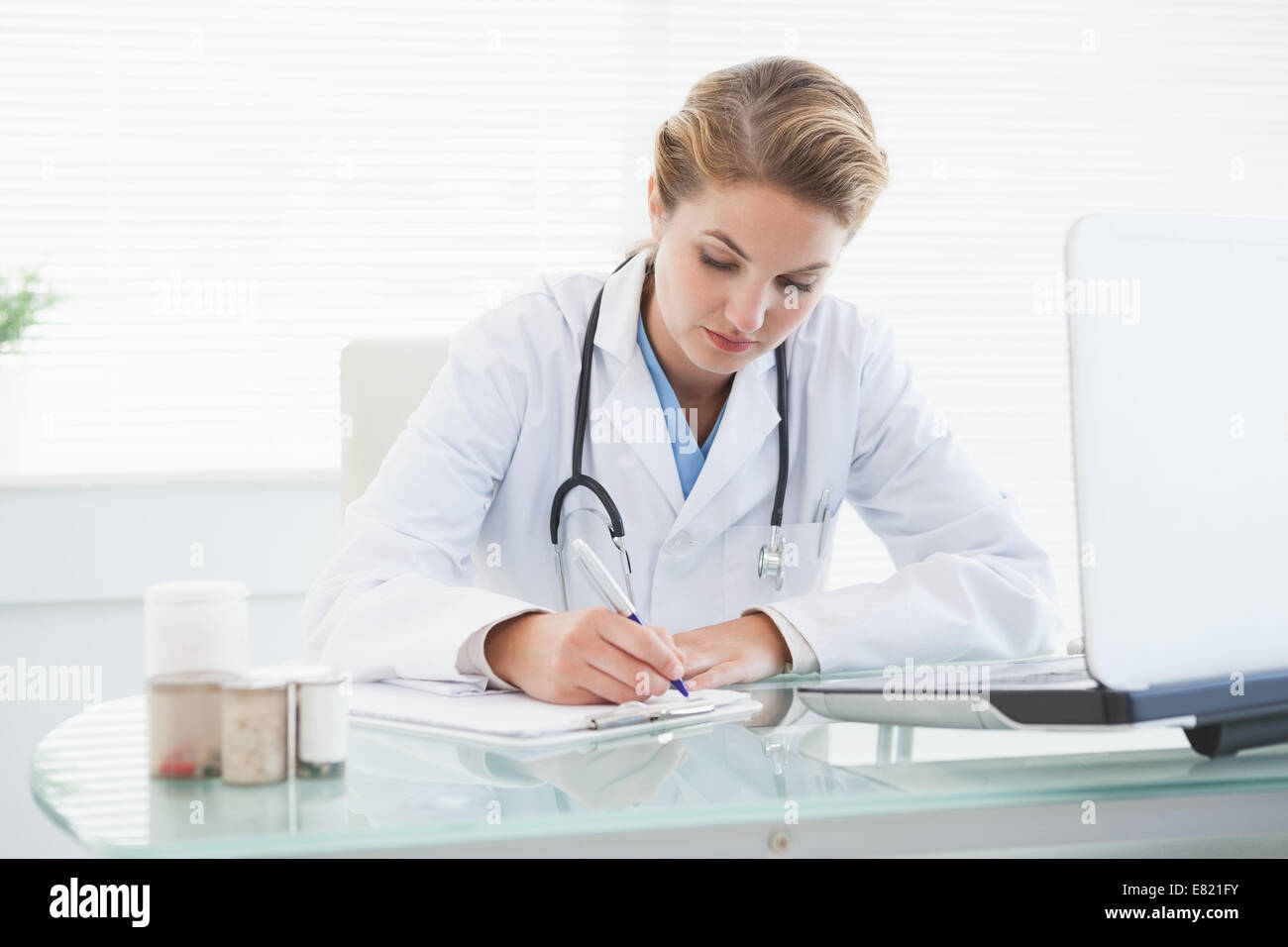 Doctor filling out prescriptions Stock Photo - Alamy