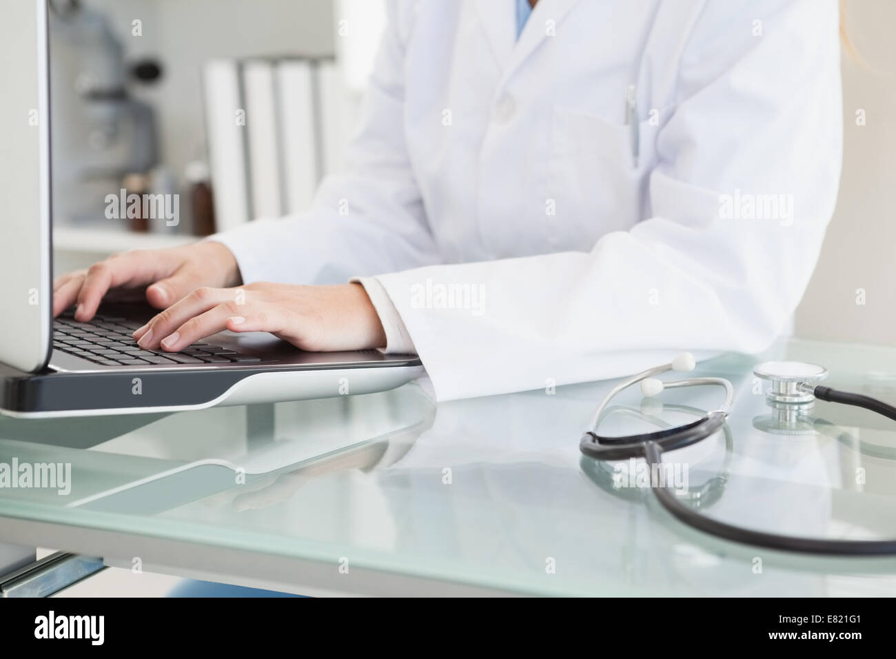 Doctor typing on her laptop Stock Photo - Alamy