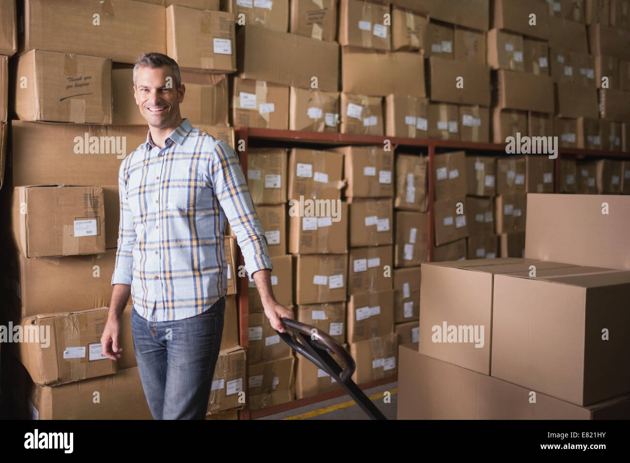 Worker with boxes in warehouse Stock Photo - Alamy