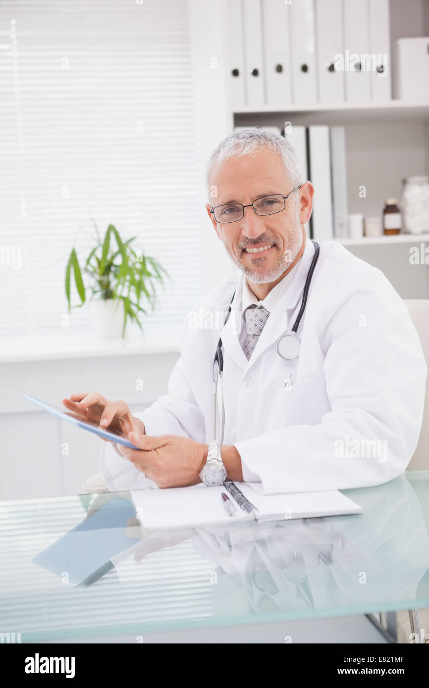 Smiling doctor using a tablet pc Stock Photo - Alamy