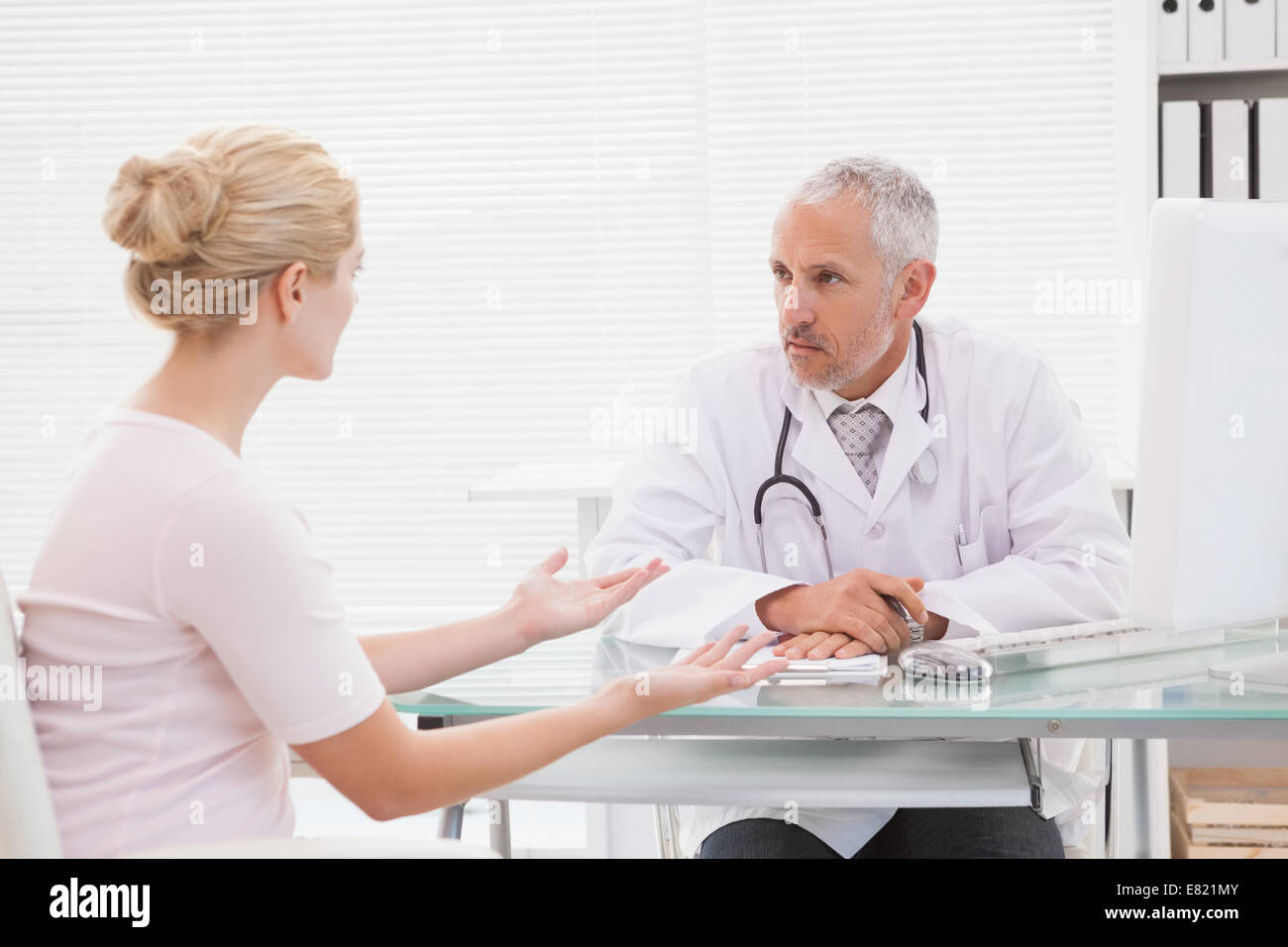 Patient consulting a serious doctor Stock Photo - Alamy