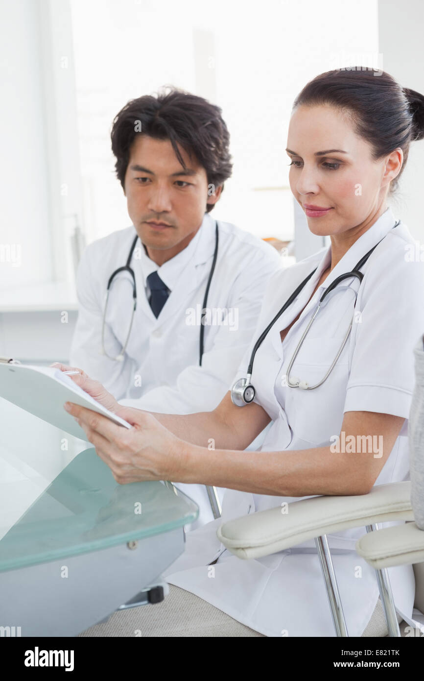 Focused doctors reviewing notes Stock Photo - Alamy