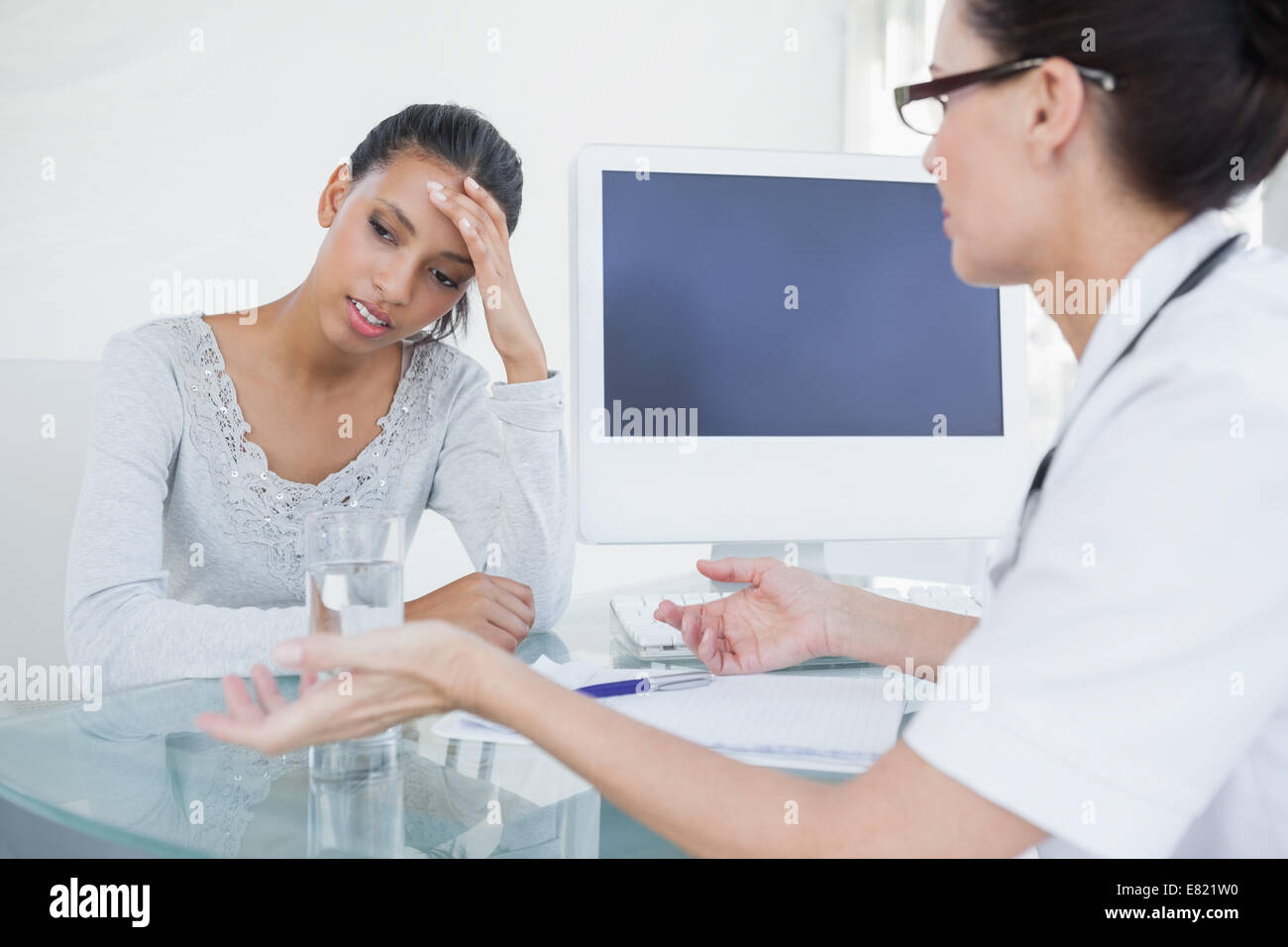 Doctor talking with upset looking patient Stock Photo - Alamy
