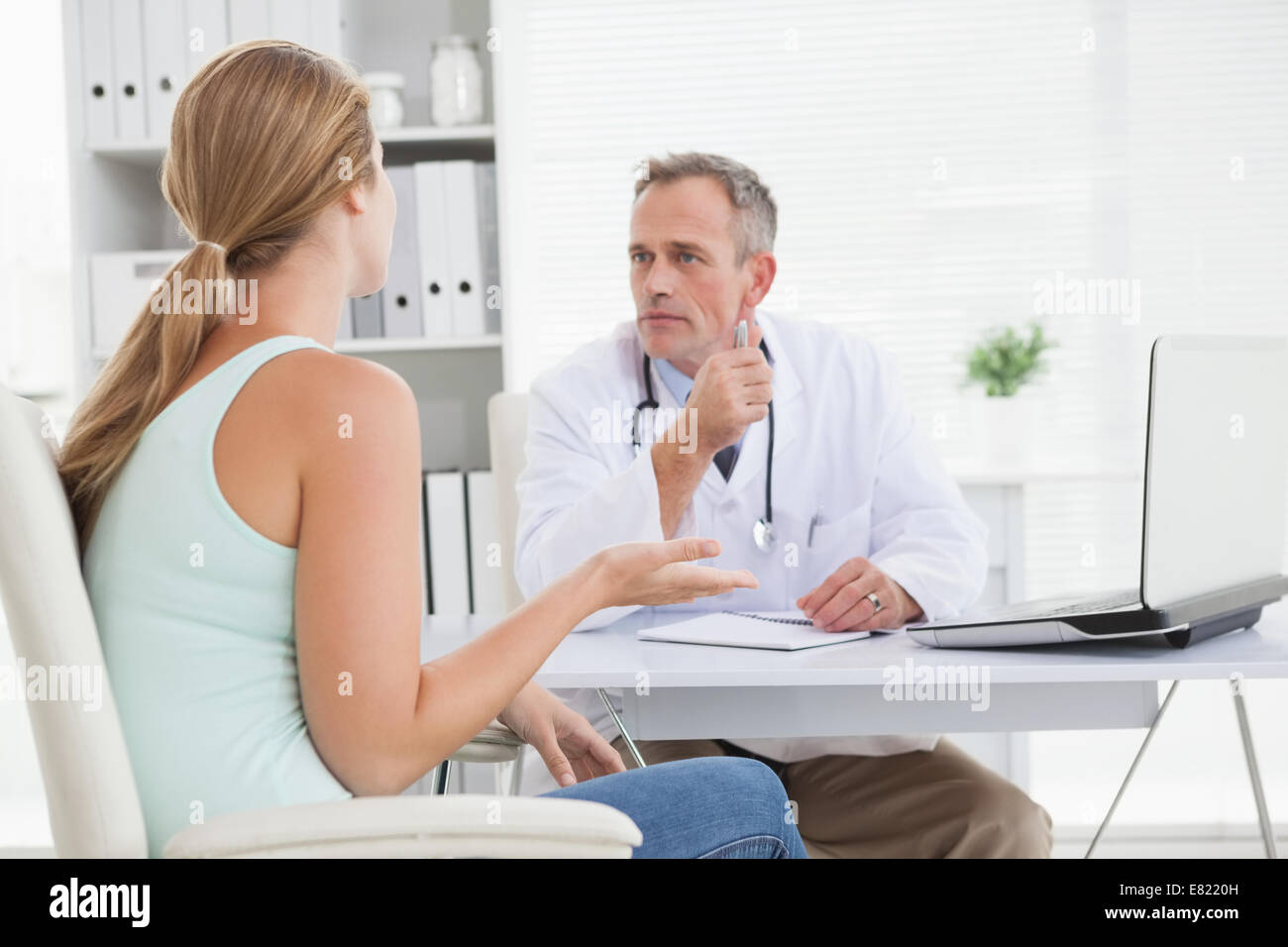 Concerned doctor talking to his patient Stock Photo - Alamy