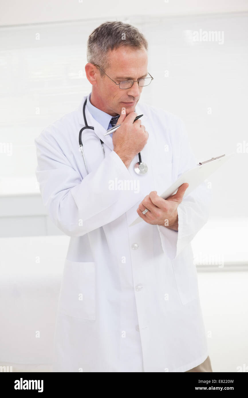 Focused doctor looking over medical notes Stock Photo - Alamy