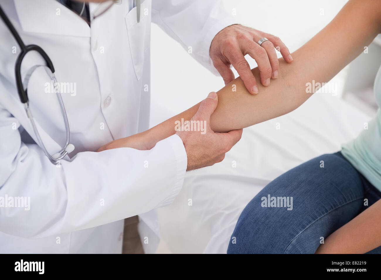 Doctor examining patients arm Stock Photo - Alamy