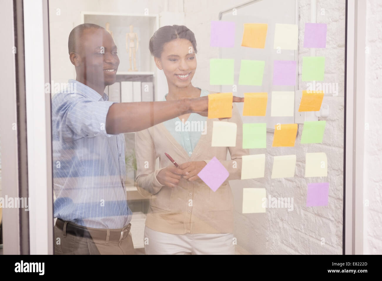Creative business team pointing adhesive notes Stock Photo - Alamy