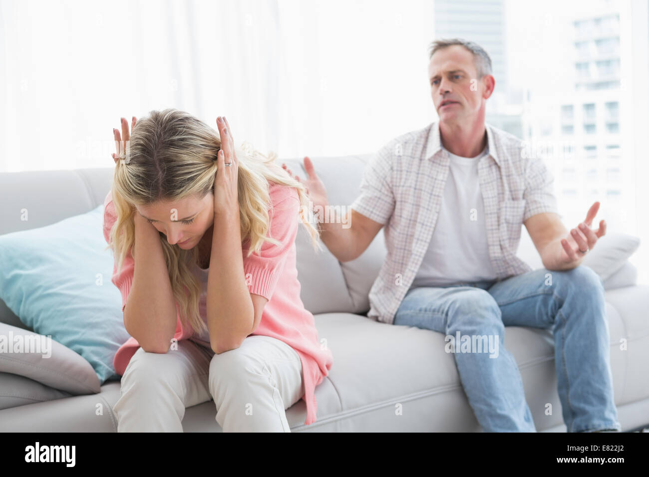 Woman ignoring her partner on the couch Stock Photo - Alamy